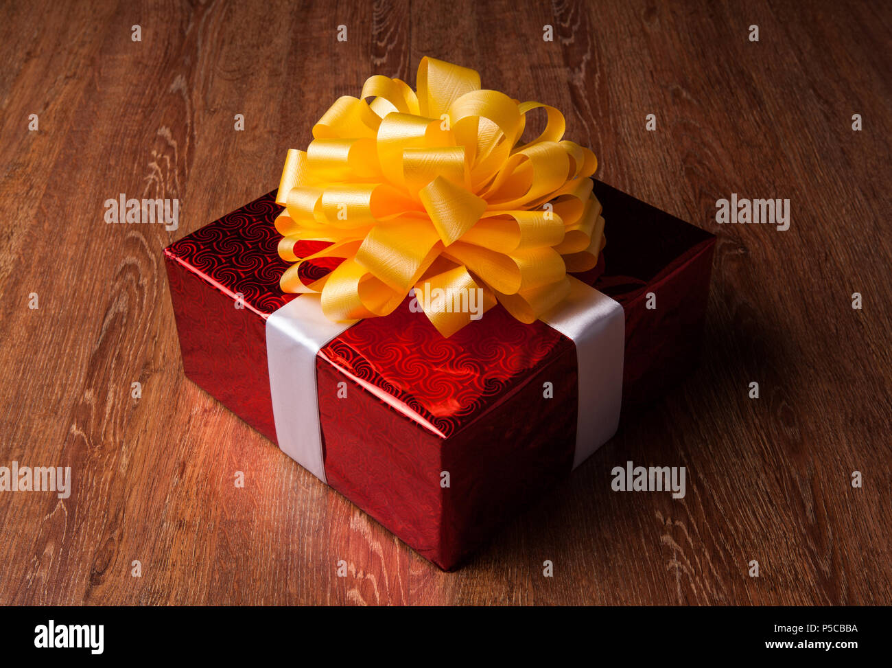 one large red gift box on a wood background Stock Photo - Alamy