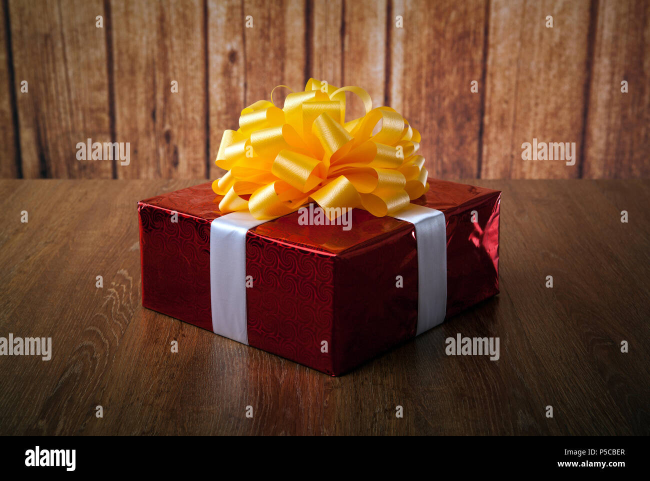 one large red gift box on a wood background Stock Photo - Alamy
