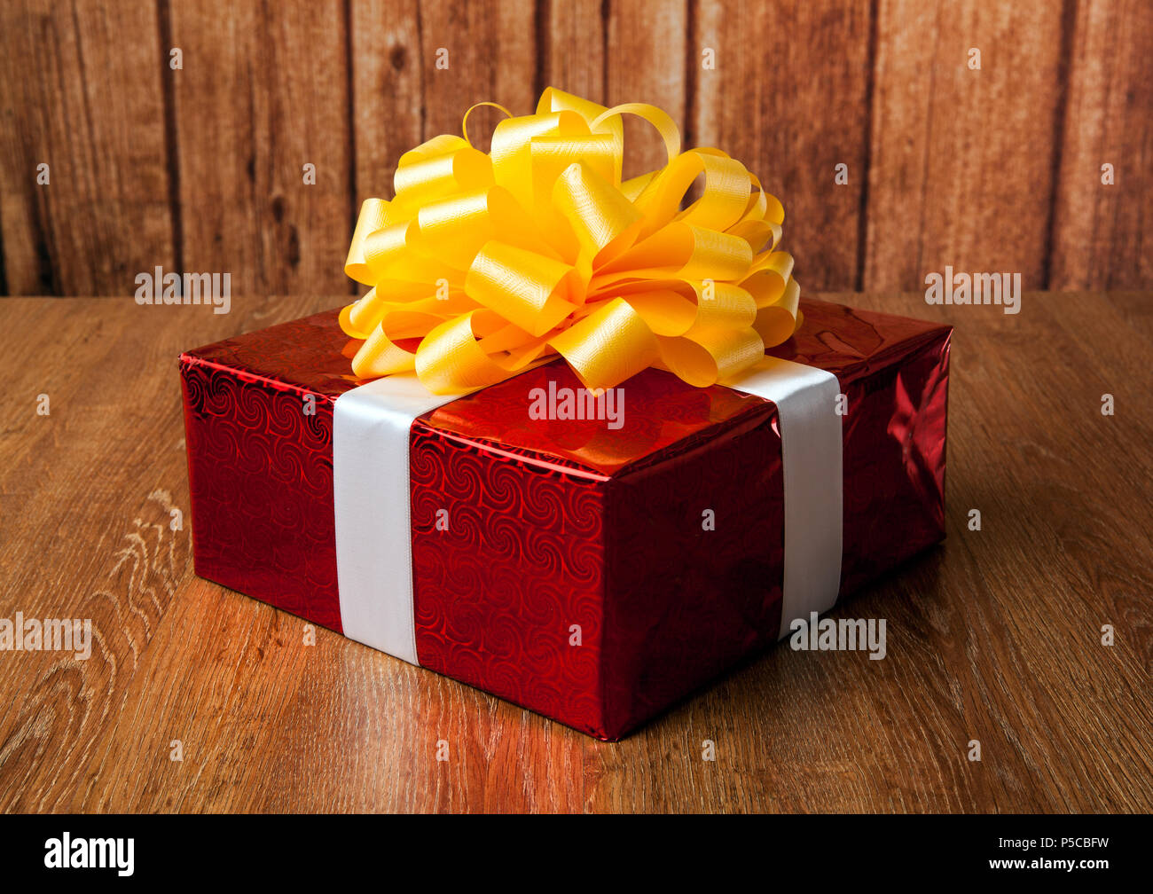 one large red gift box on a wood background Stock Photo - Alamy
