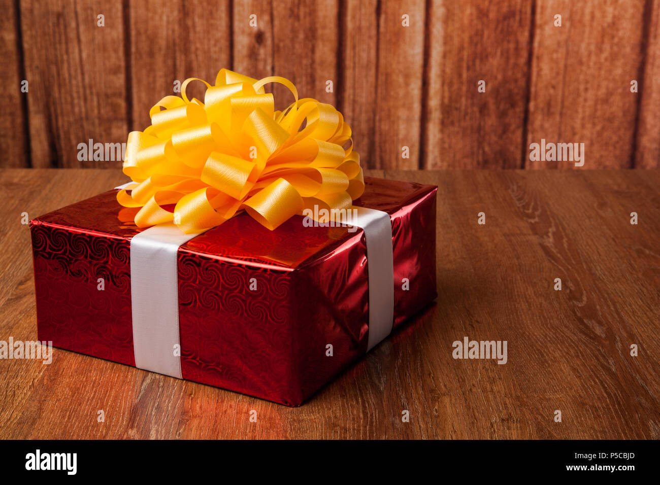 one large red gift box on a wood background Stock Photo - Alamy