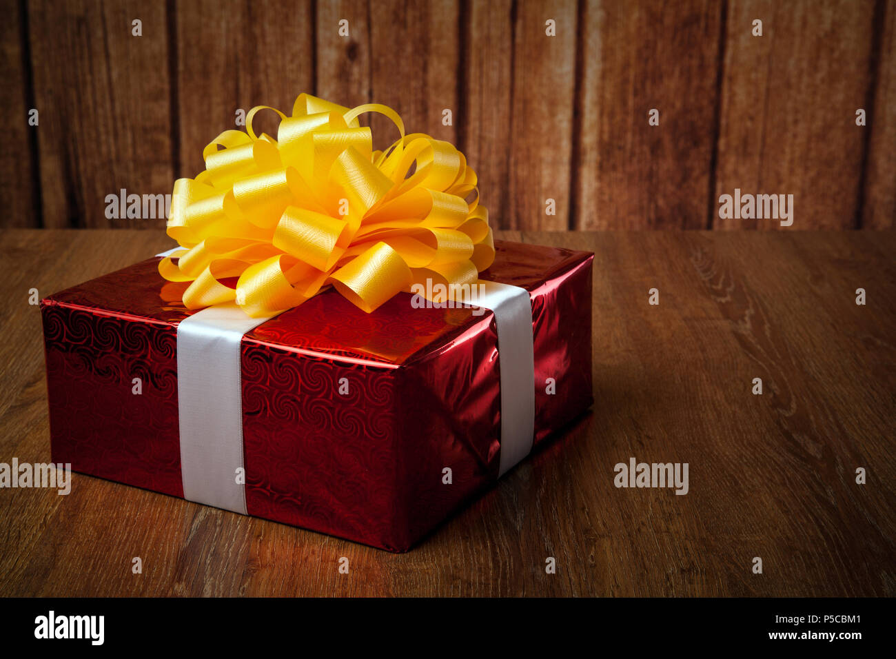 one large red gift box on a wood background Stock Photo - Alamy