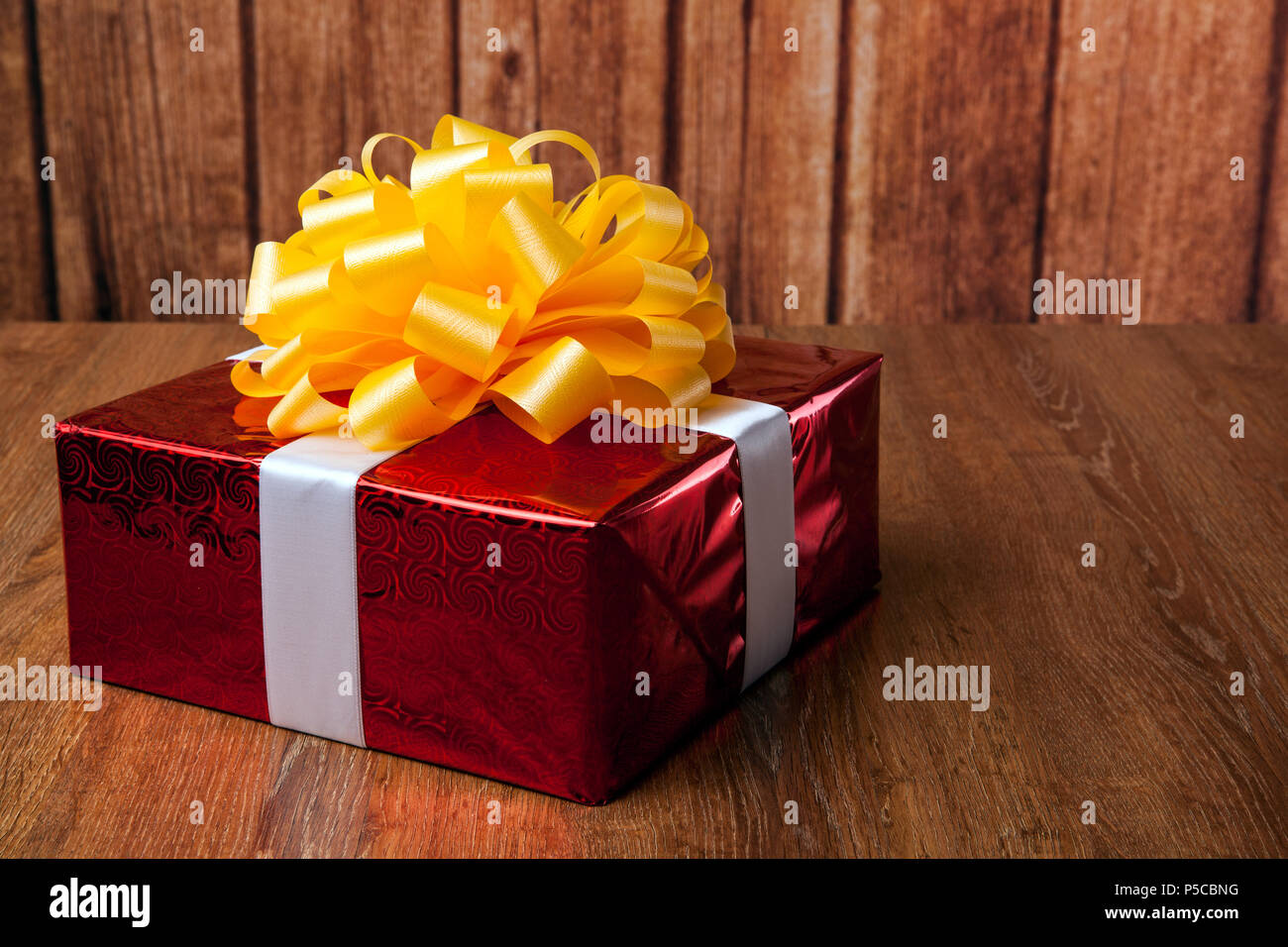 one large red gift box on a wood background Stock Photo - Alamy