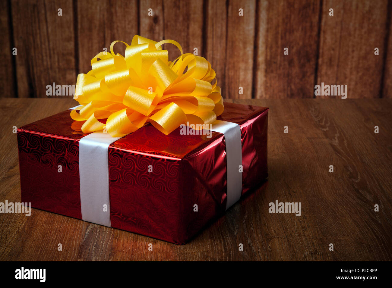 one large red gift box on a wood background Stock Photo - Alamy