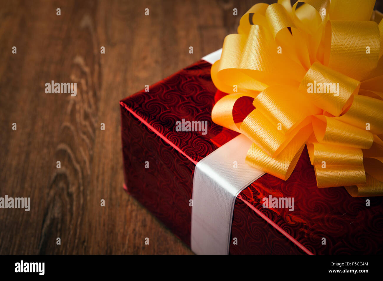 one large red gift box on a wood background Stock Photo - Alamy
