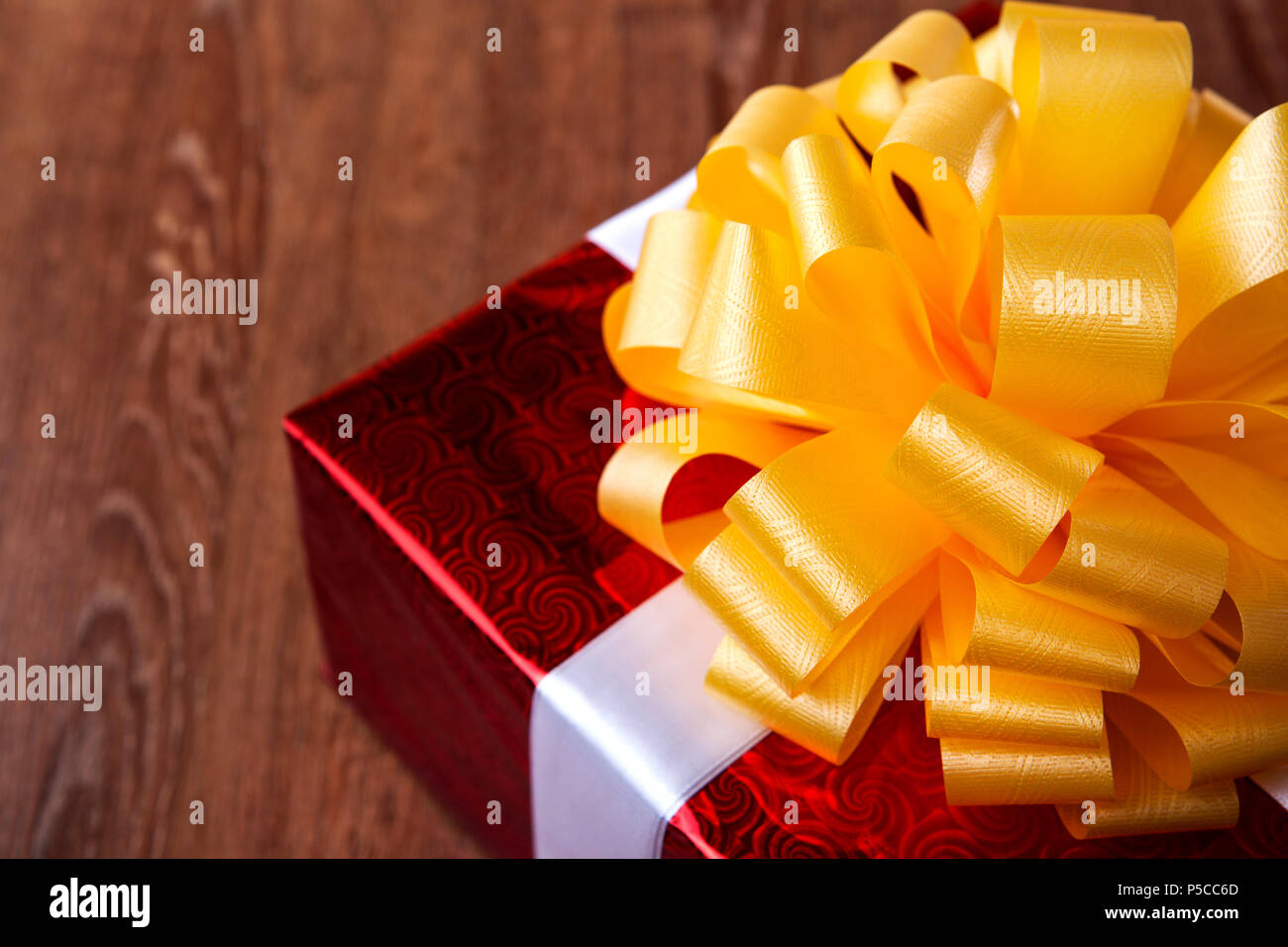 one large red gift box on a wood background Stock Photo - Alamy