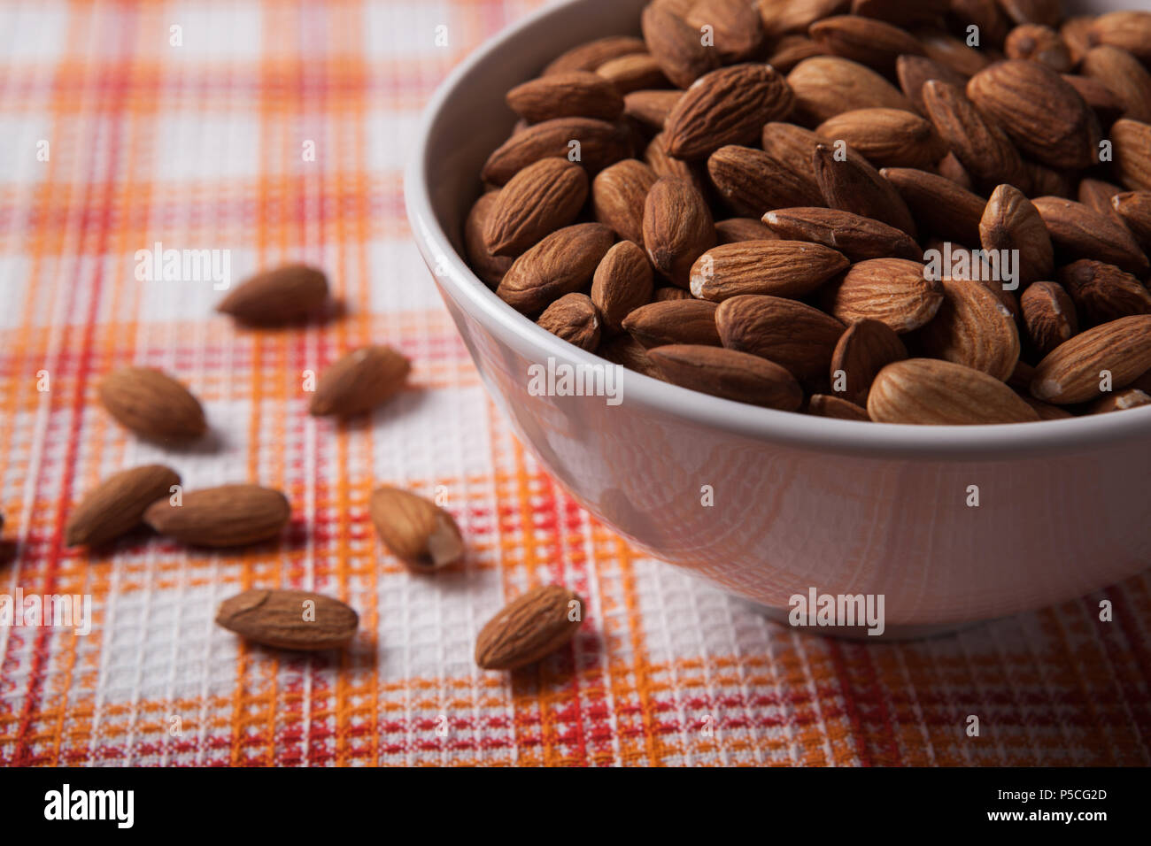 large grains of almonds in the shell and the bowl close up Stock Photo ...