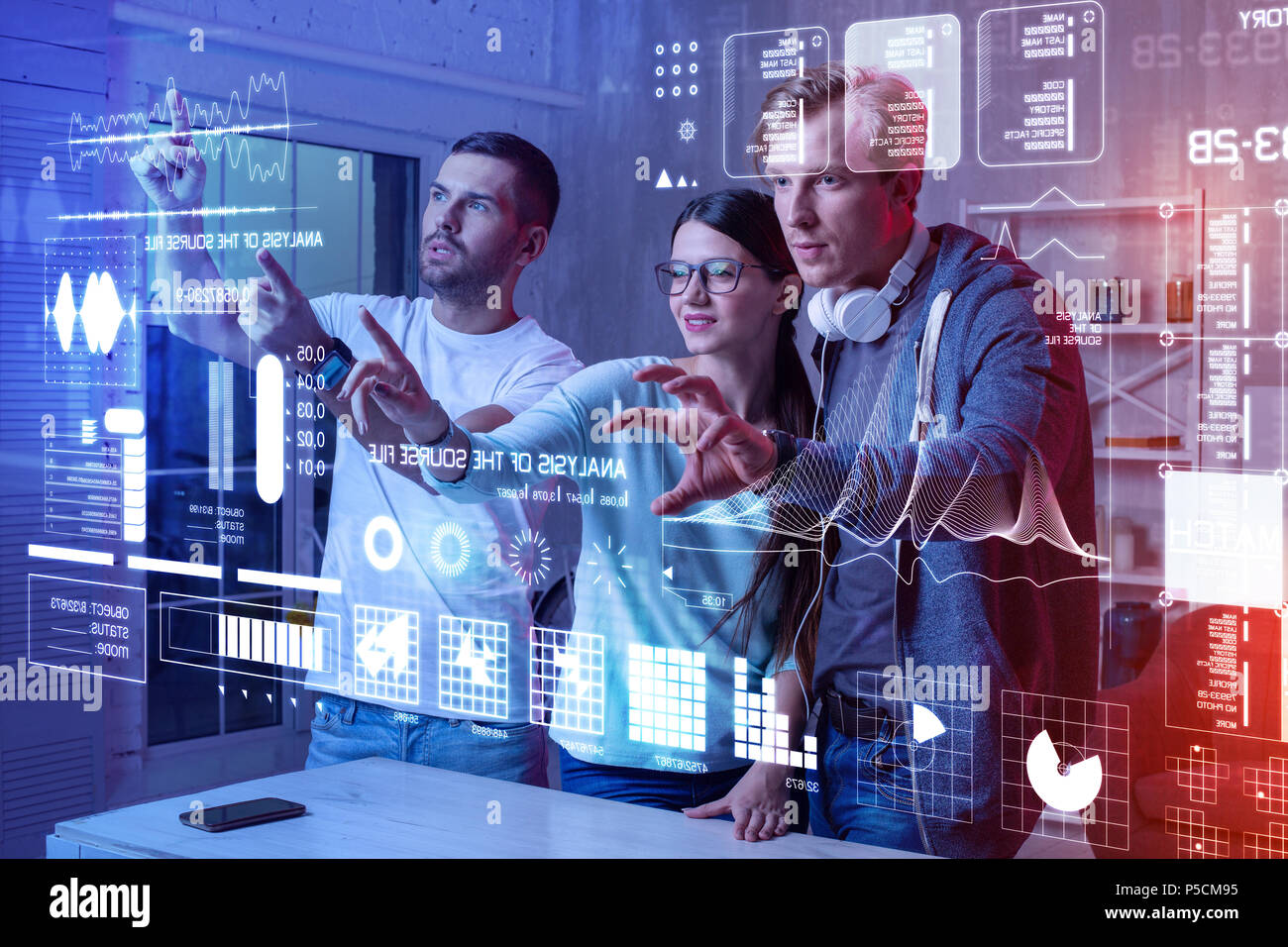 Creative web developers touching holograms while working Stock Photo ...