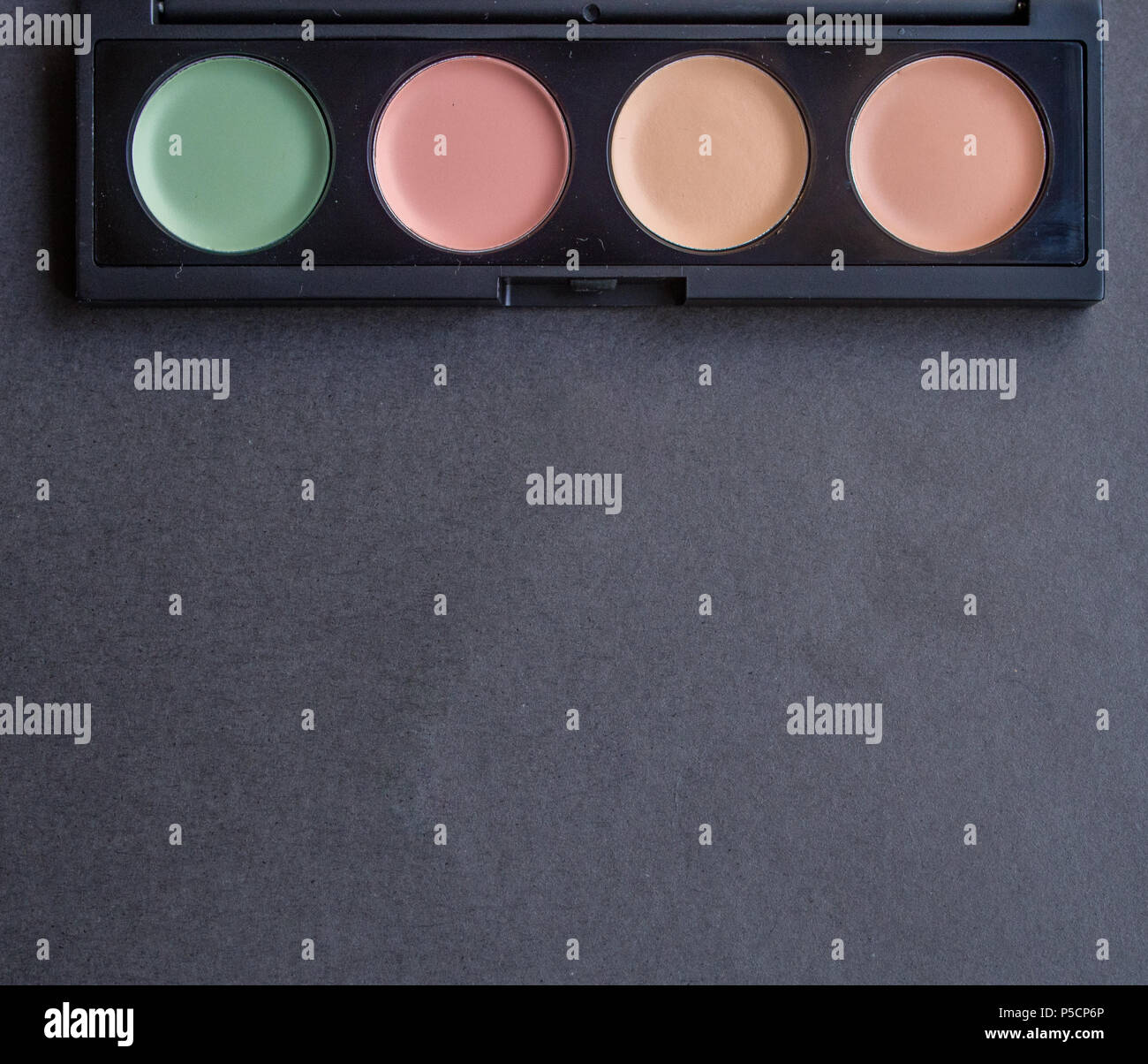 Palette with different makeup correctors on black background Stock ...