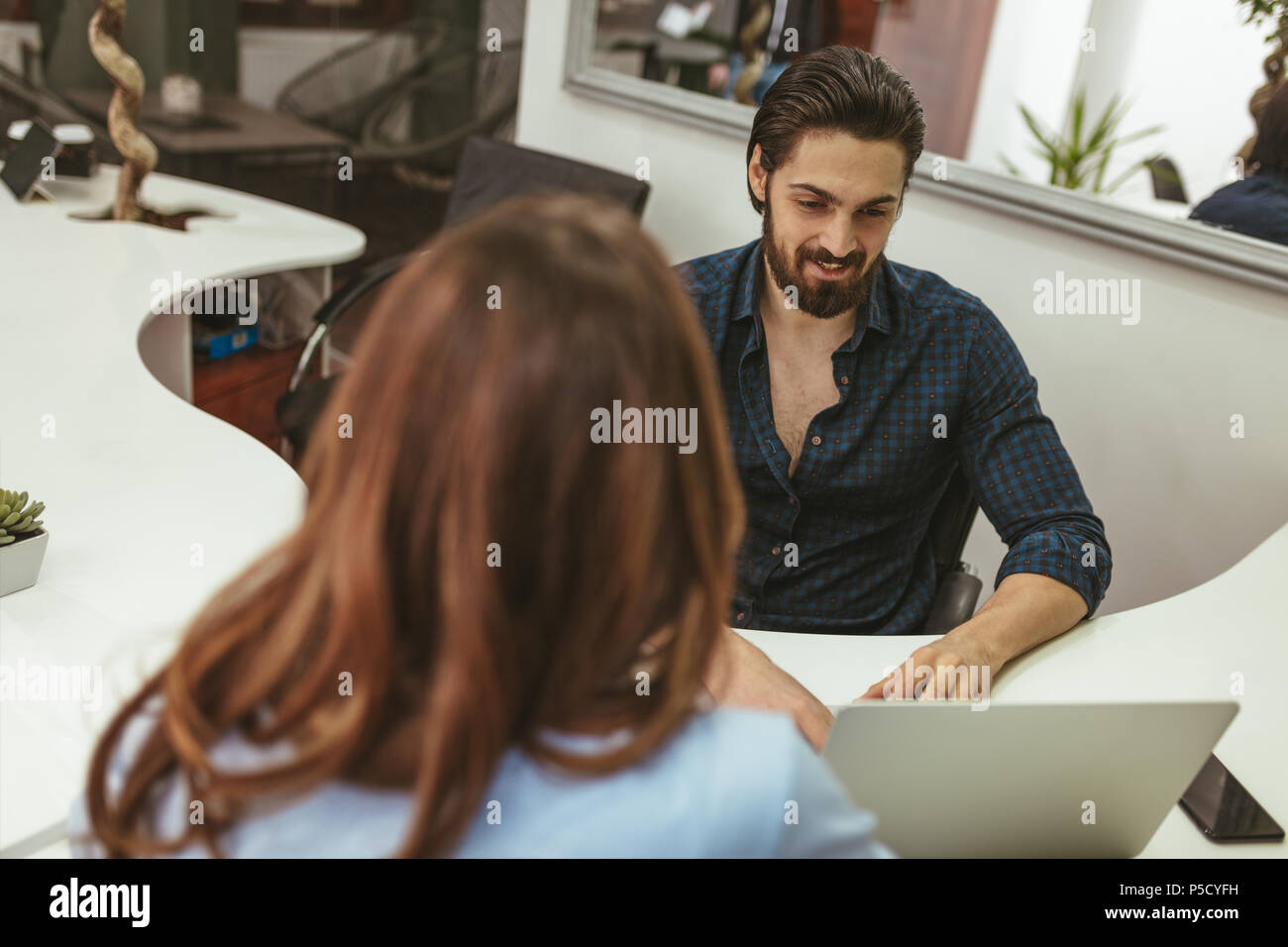 A young man gives an interview for a job, and the data is taken by a ...
