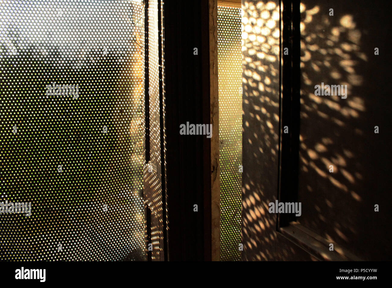 Light bleeding through grated panel to open door Stock Photo - Alamy