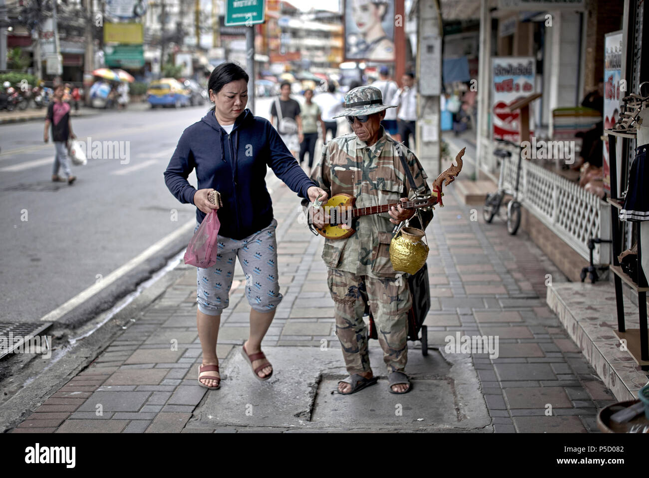 Blind musician playing the traditional Thai double necked Phin lute ...