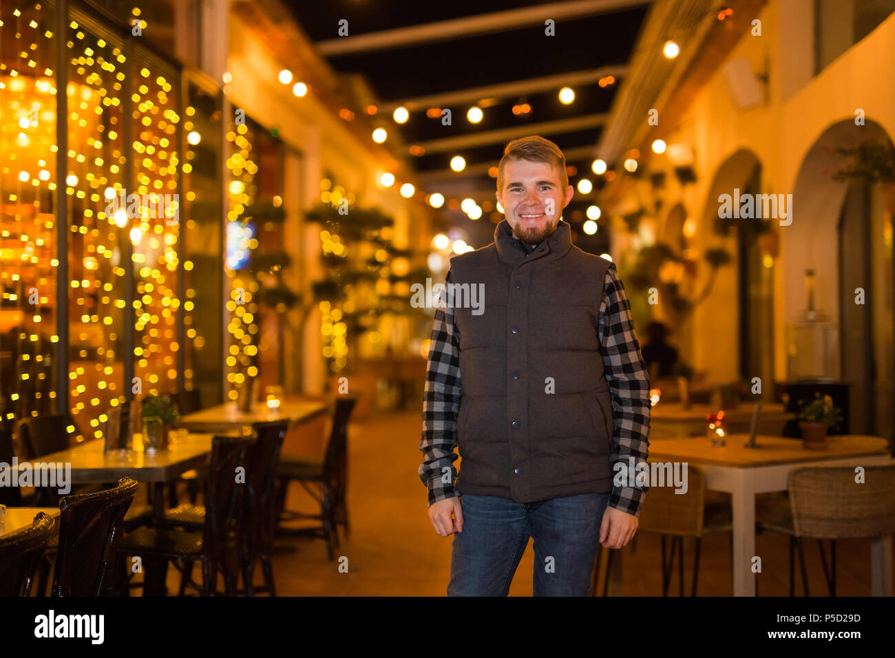 Young smiling guy posing at night in cafe Stock Photo - Alamy