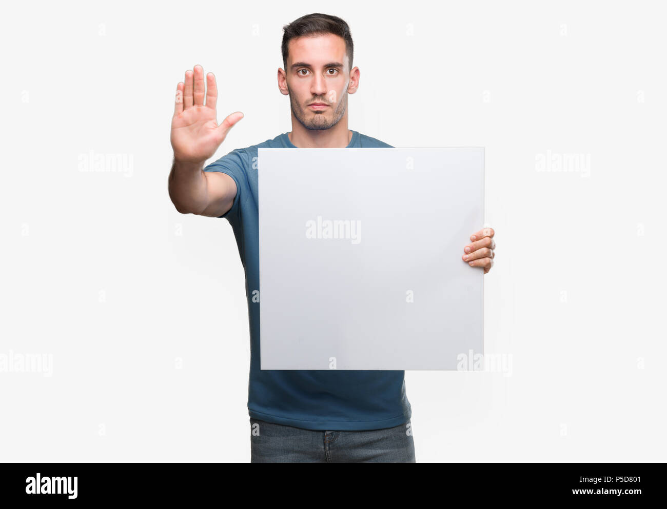 Handsome young man holding advertising banner with open hand doing stop ...