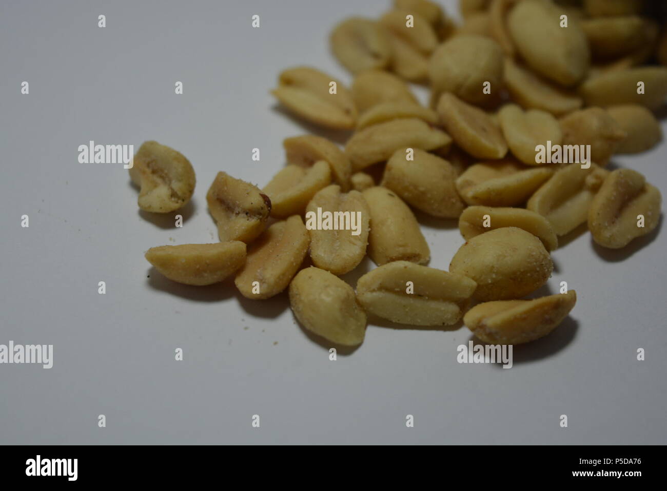 Healthy food, nuts, lots of toasted peanuts placed on a white ...