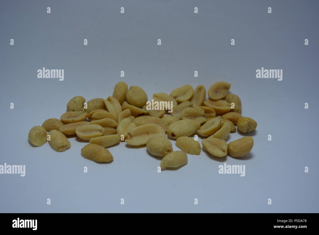 Healthy food, nuts, lots of toasted peanuts placed on a white ...