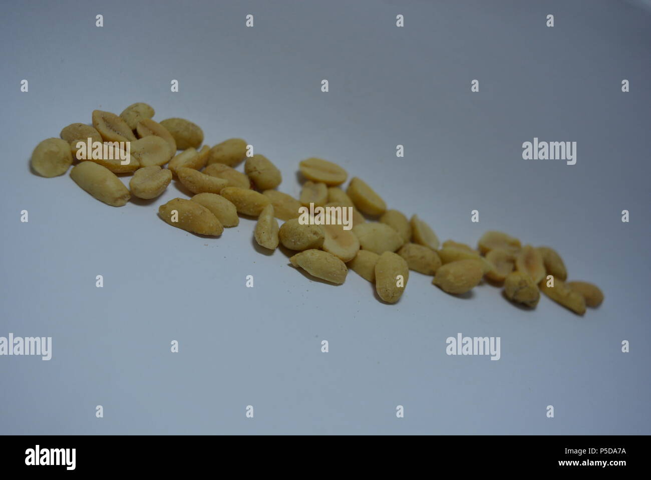 Healthy food, nuts, lots of toasted peanuts placed on a white ...