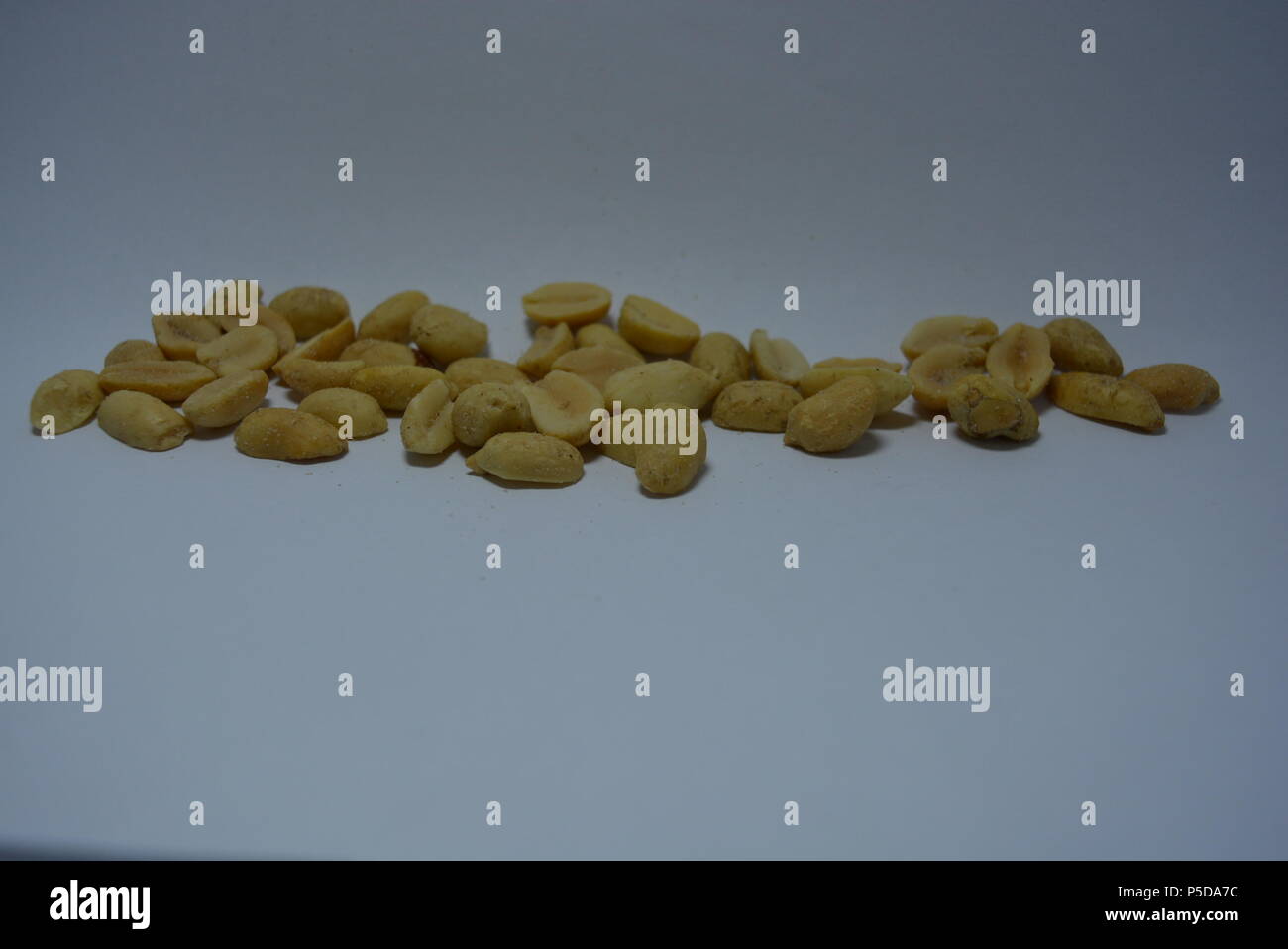 Healthy food, nuts, lots of toasted peanuts placed on a white ...