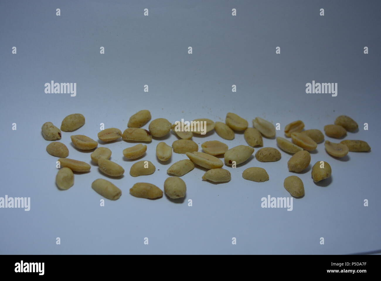 Healthy food, nuts, lots of toasted peanuts placed on a white ...