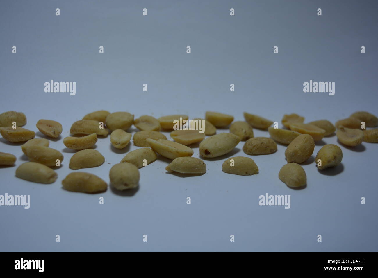 Healthy food, nuts, lots of toasted peanuts placed on a white ...