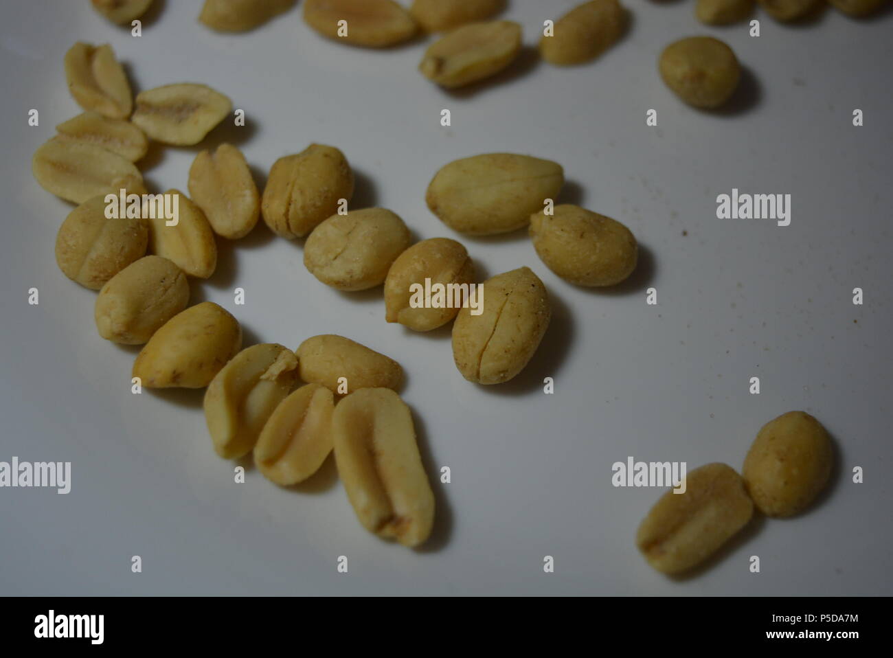 Healthy food, nuts, lots of toasted peanuts placed on a white ...