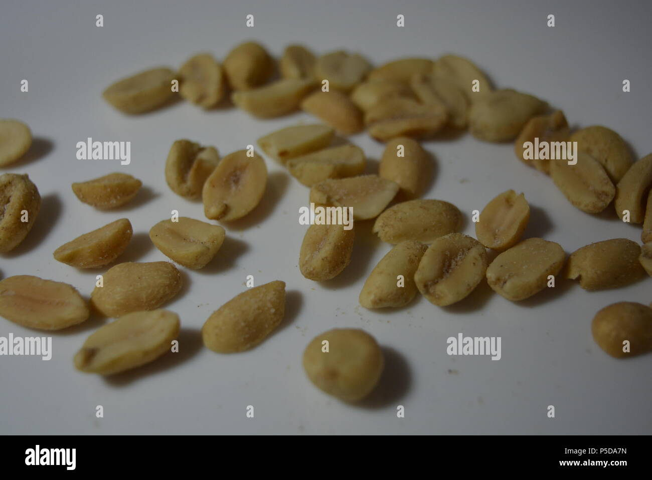 Healthy food, nuts, lots of toasted peanuts placed on a white ...