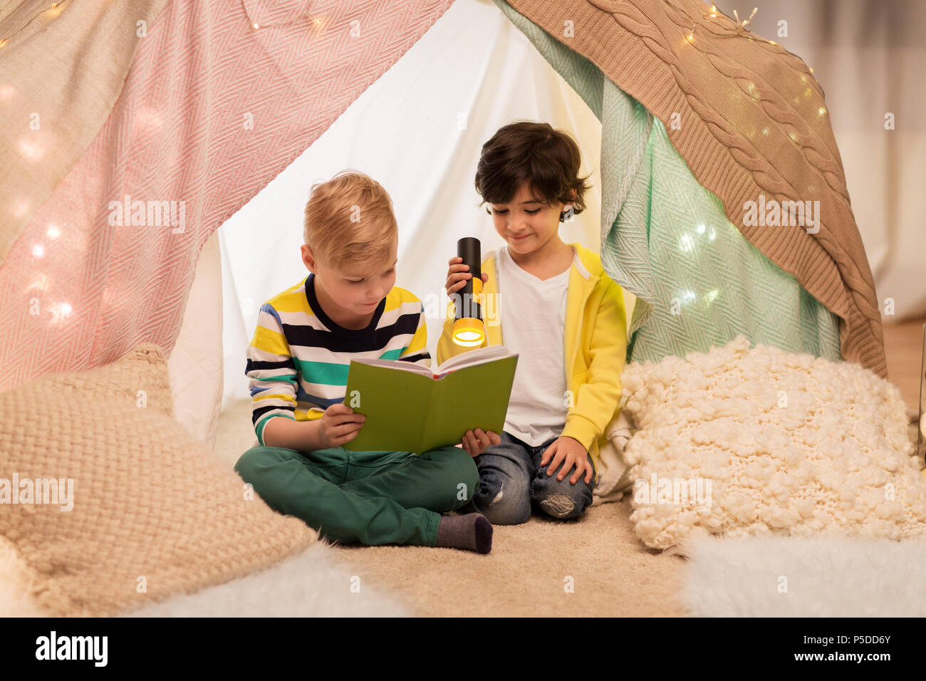 happy boys reading book in kids tent at home Stock Photo - Alamy