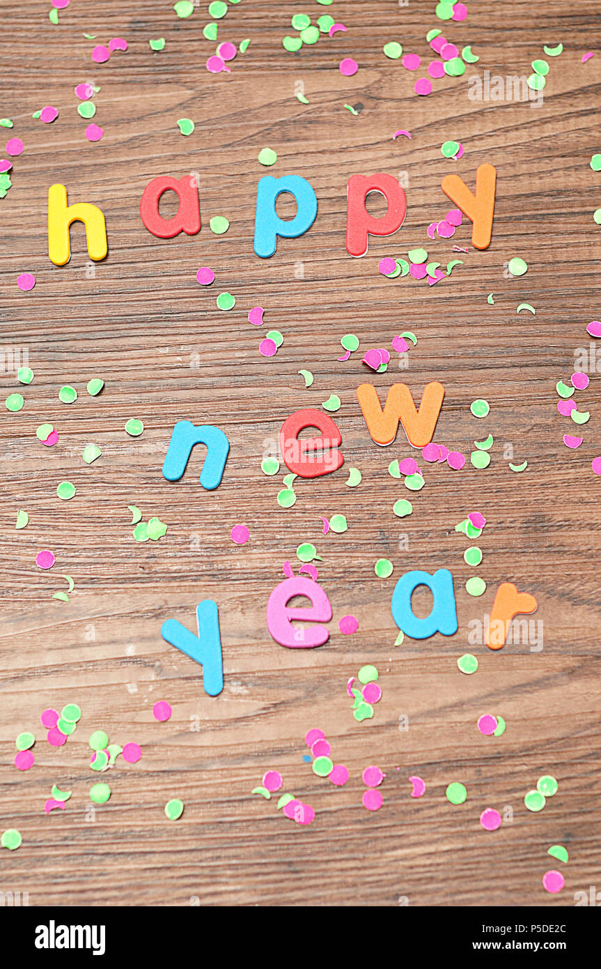Happy New Year in colorful letters with confetti Stock Photo - Alamy