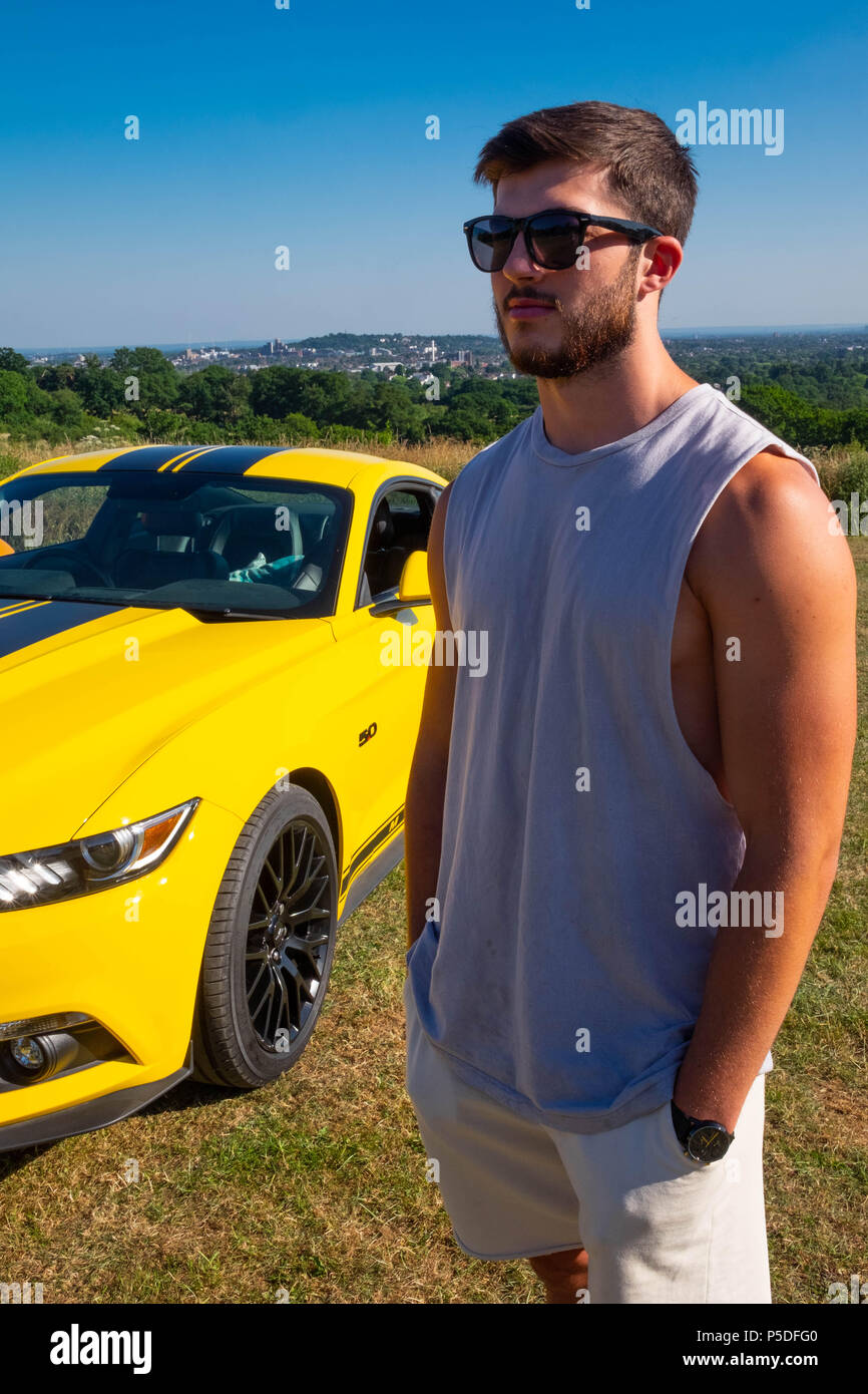 Muscular young man poses with a European Ford Mustang 5 litre V8 GT ...