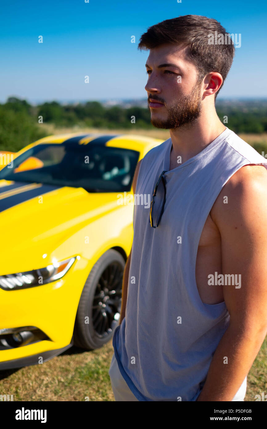 Muscular young man poses with a European Ford Mustang 5 litre V8 GT ...