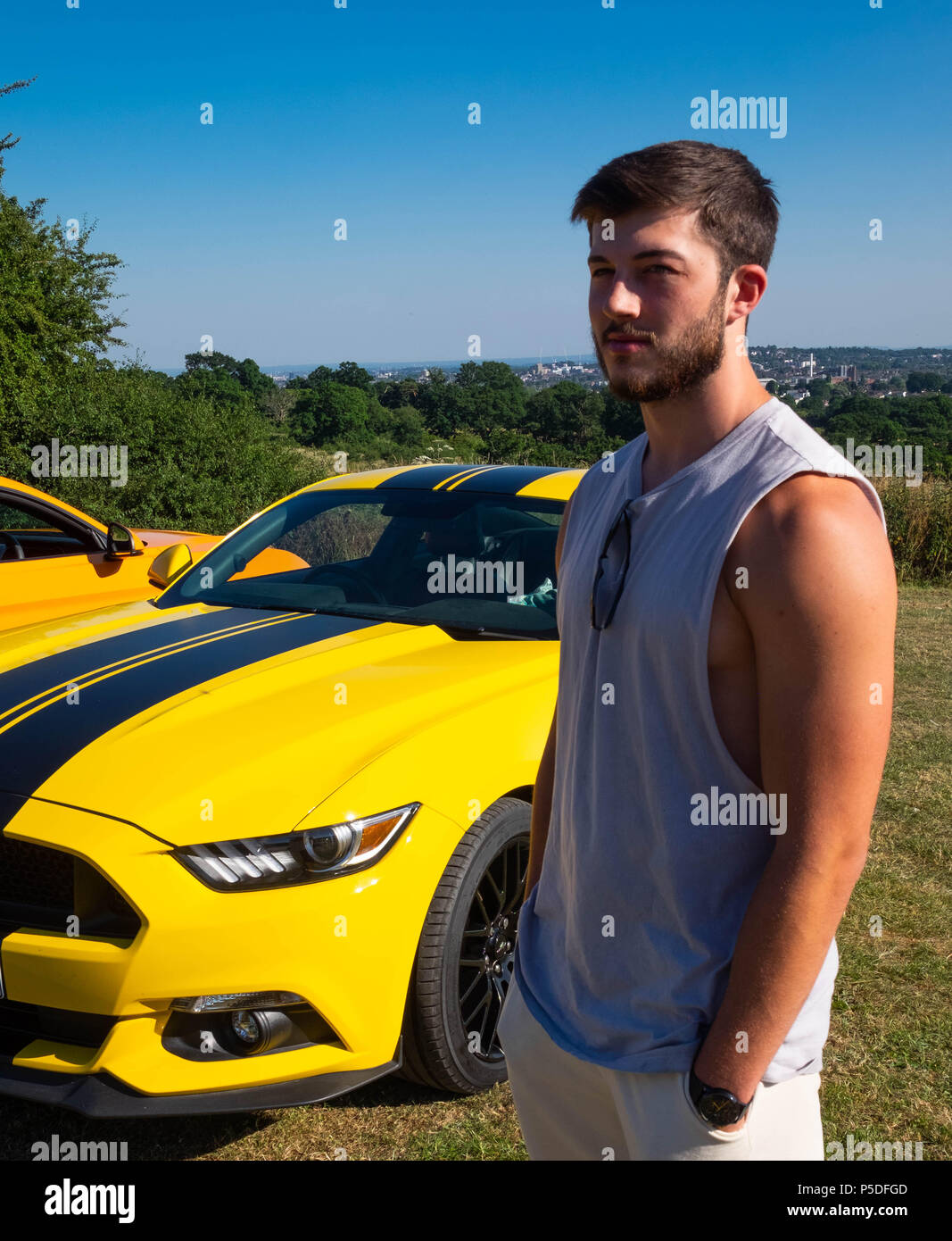Muscular young man poses with a European Ford Mustang 5 litre V8 GT ...
