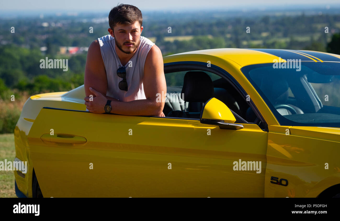 Muscular young man poses with a European Ford Mustang 5 litre V8 GT ...