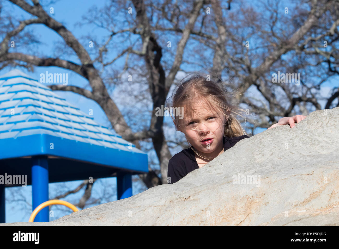 Girl Hiding Behind Rock Stock Photo - Alamy