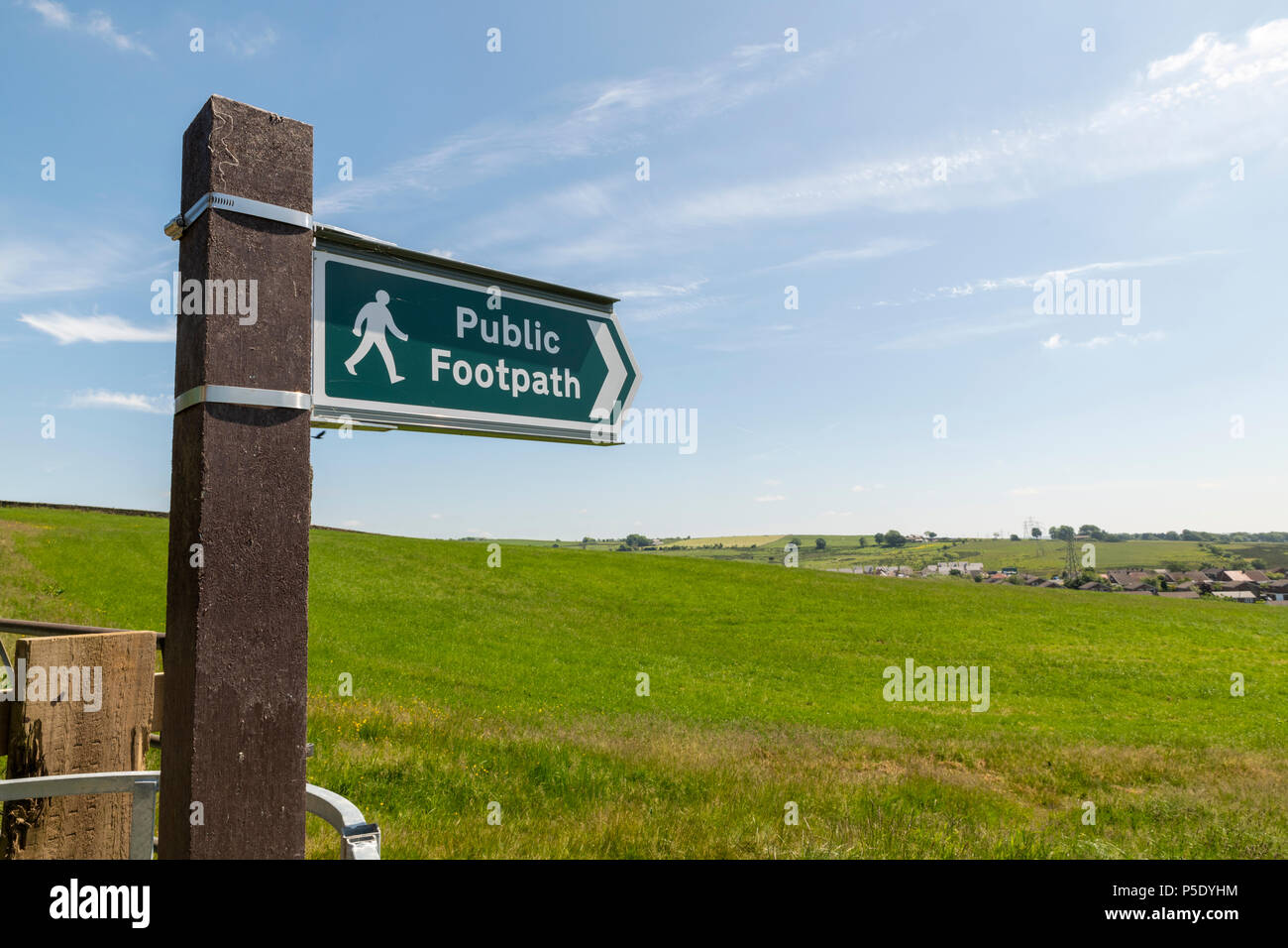 Public Footpath Sign with blue sky and green feild in a greenbelt ...