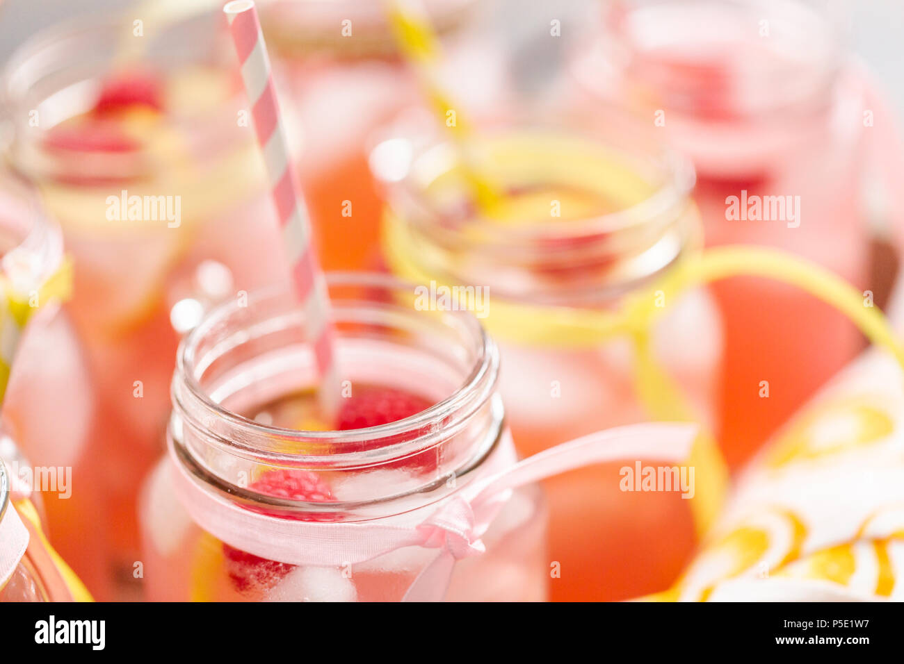 Raspberry lemonade garnished with fresh lemon and raspberries in ...