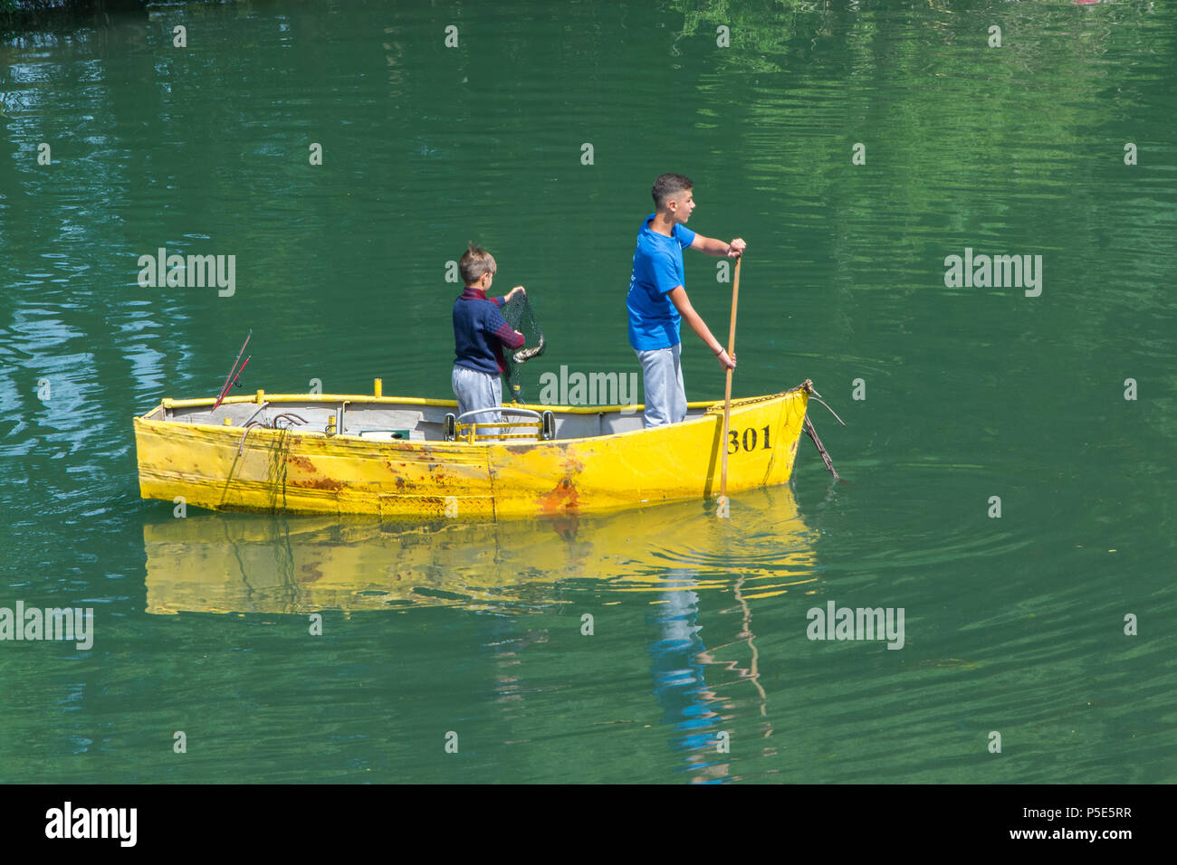 Two brothers (young boy and a small child) fishing alone with the boat ...