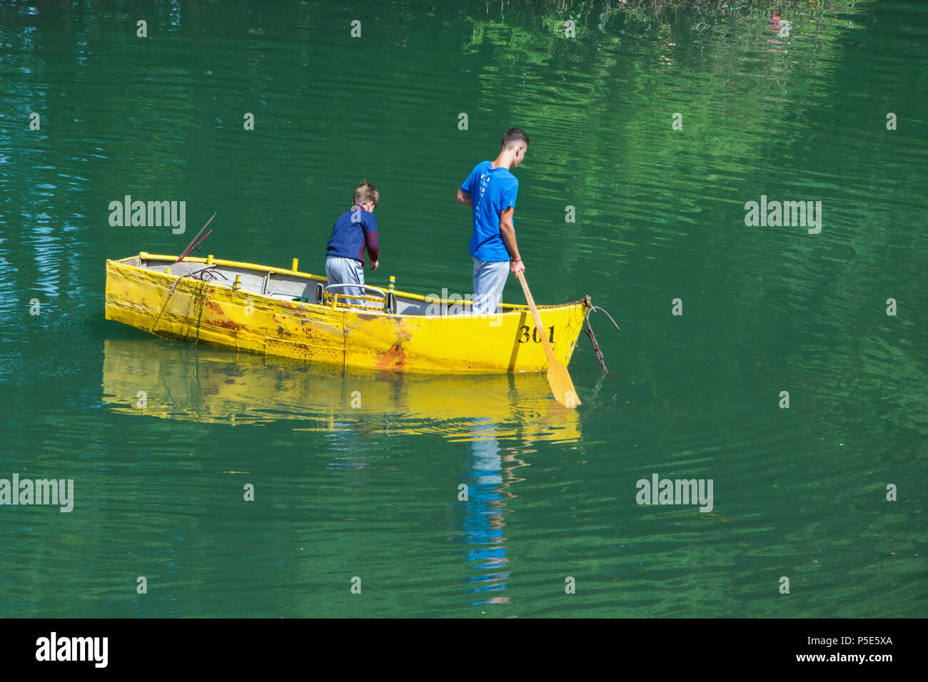 Two brothers (young boy and a small child) fishing alone with the boat ...