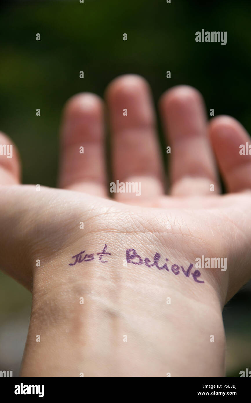 Handwritten motivational phrase on the human hand "Just believe Stock ...