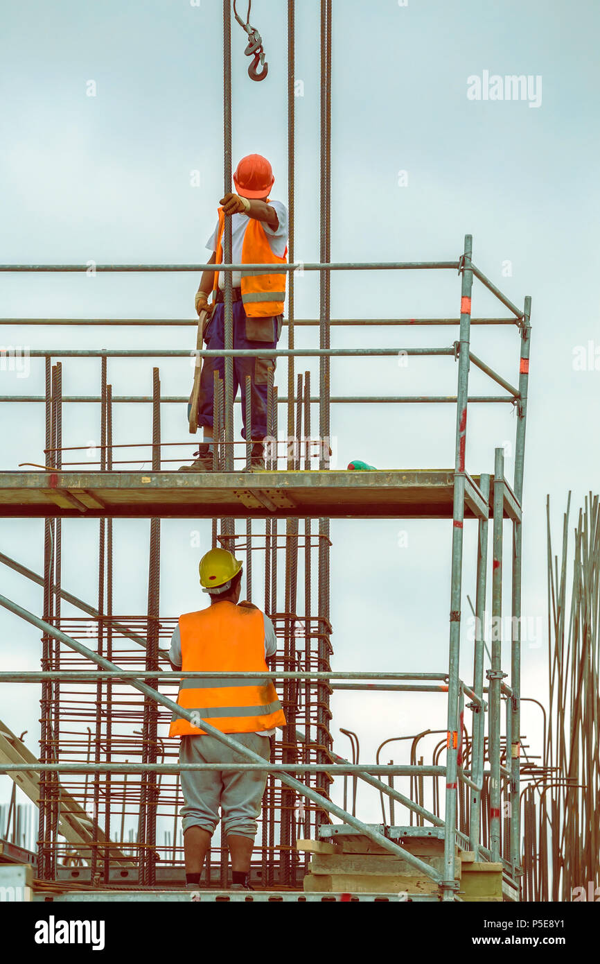 Reinforcement work with metal rods at construction site. Vintage style ...