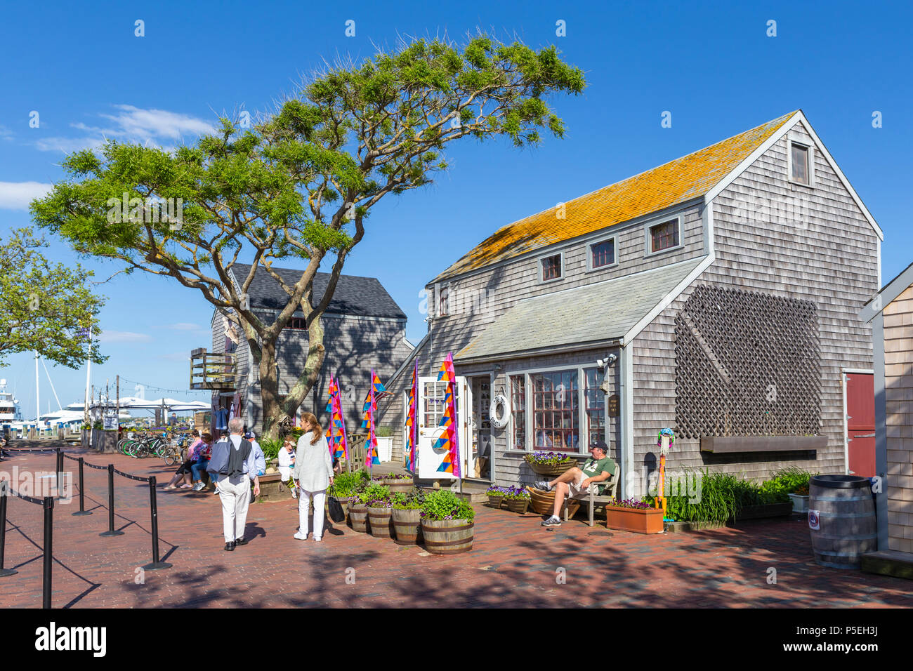 Tourists and visitors shop and stroll along Straight Wharf in Nantucket ...