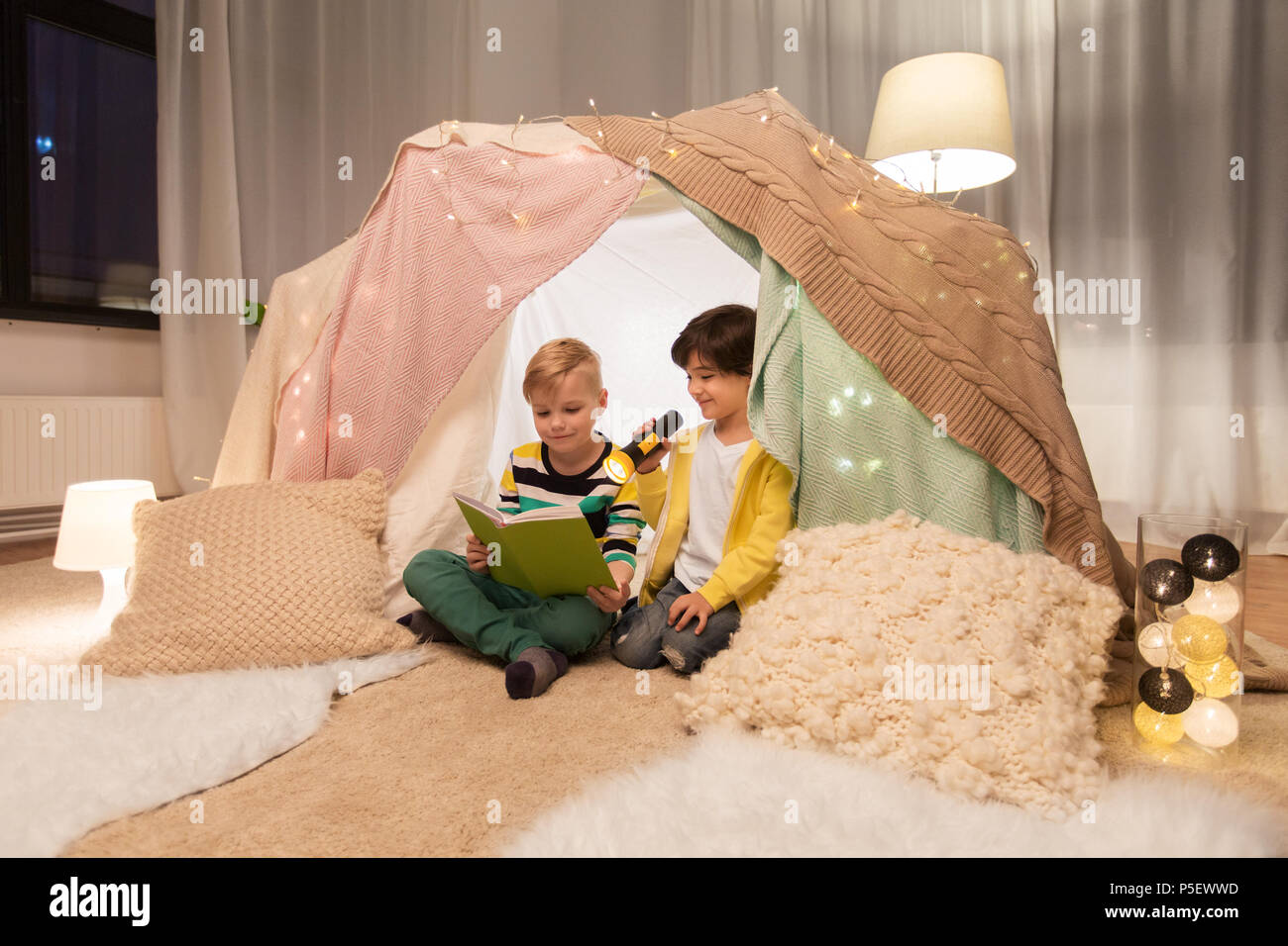 happy boys reading book in kids tent at home Stock Photo - Alamy