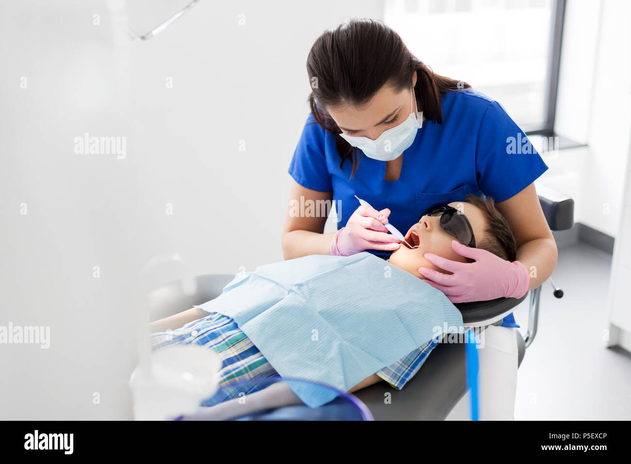 dentist checking for kid teeth at dental clinic Stock Photo - Alamy