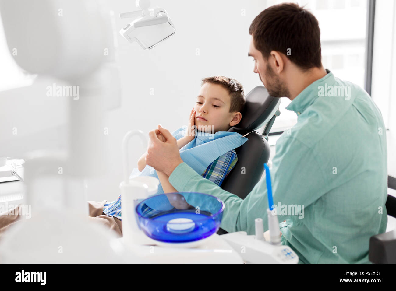 father supporting son at dental clinic Stock Photo - Alamy