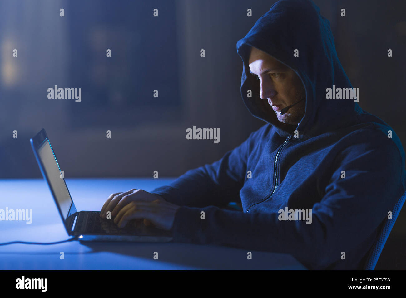 hacker with microphone and laptop in dark room Stock Photo - Alamy