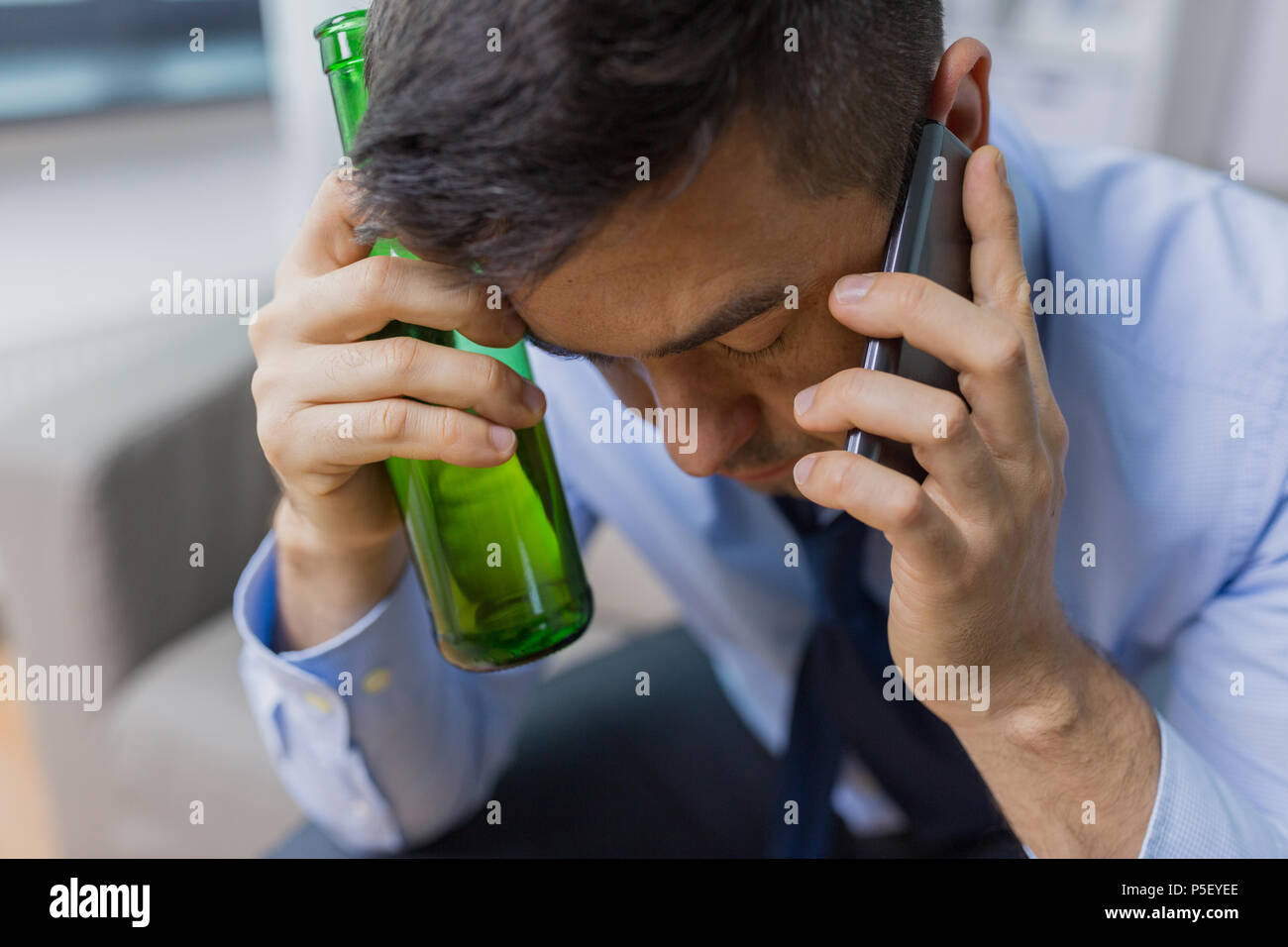 man with bottle of alcohol calling on smartphone Stock Photo - Alamy