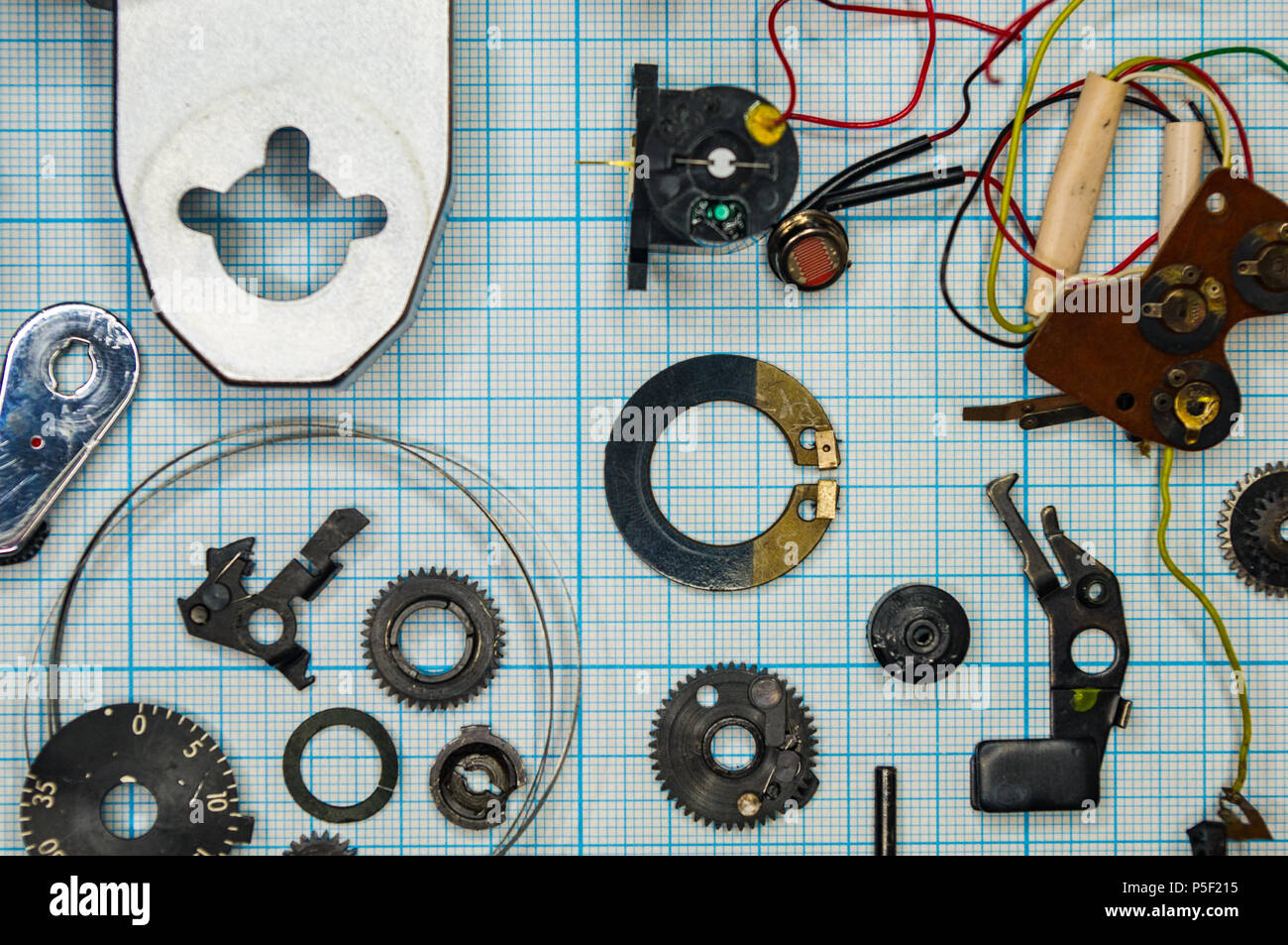parts are completely disassembled old retro film SLR camera on graph ...