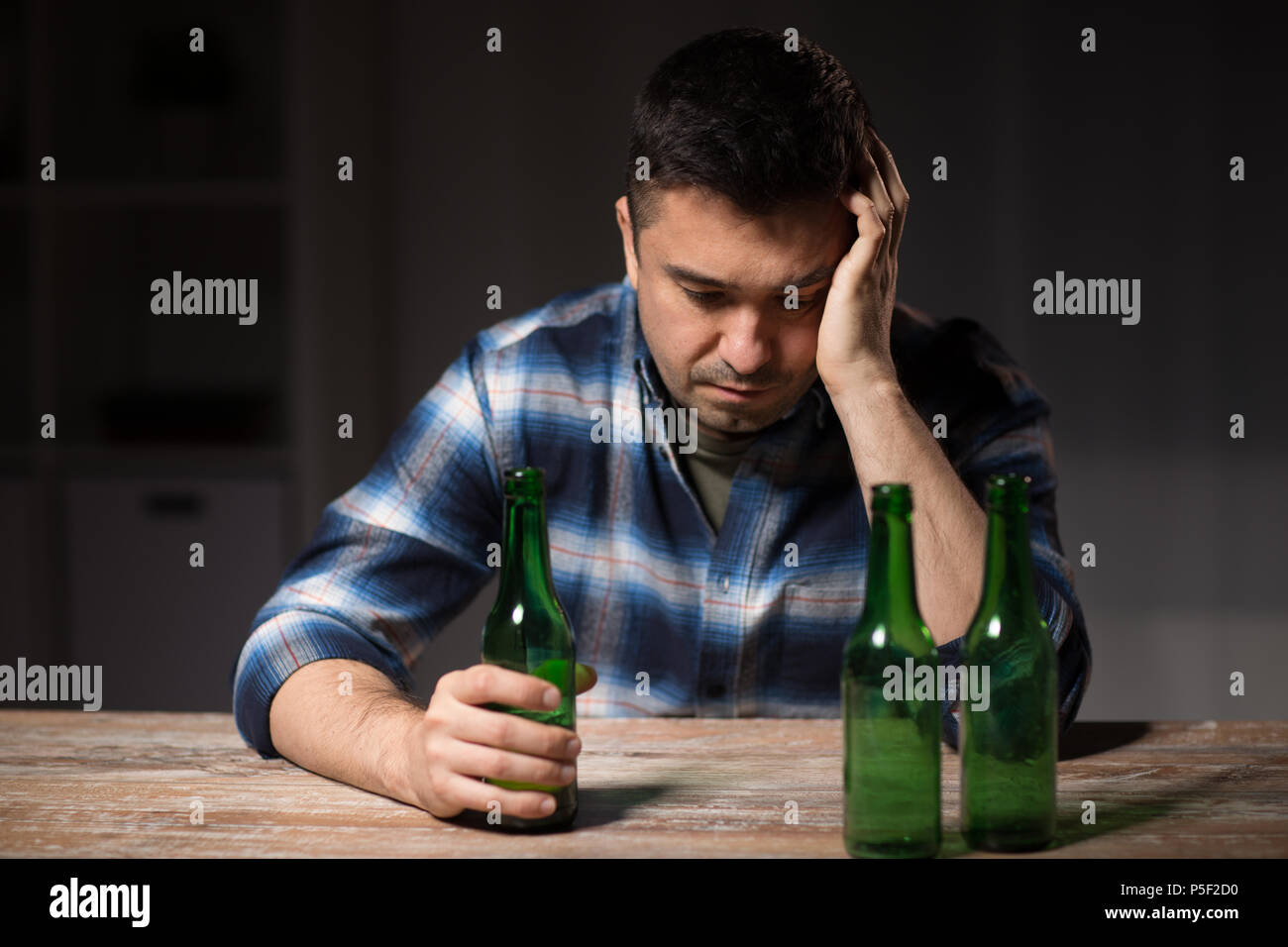 drunk man drinking alcohol at table at night Stock Photo - Alamy