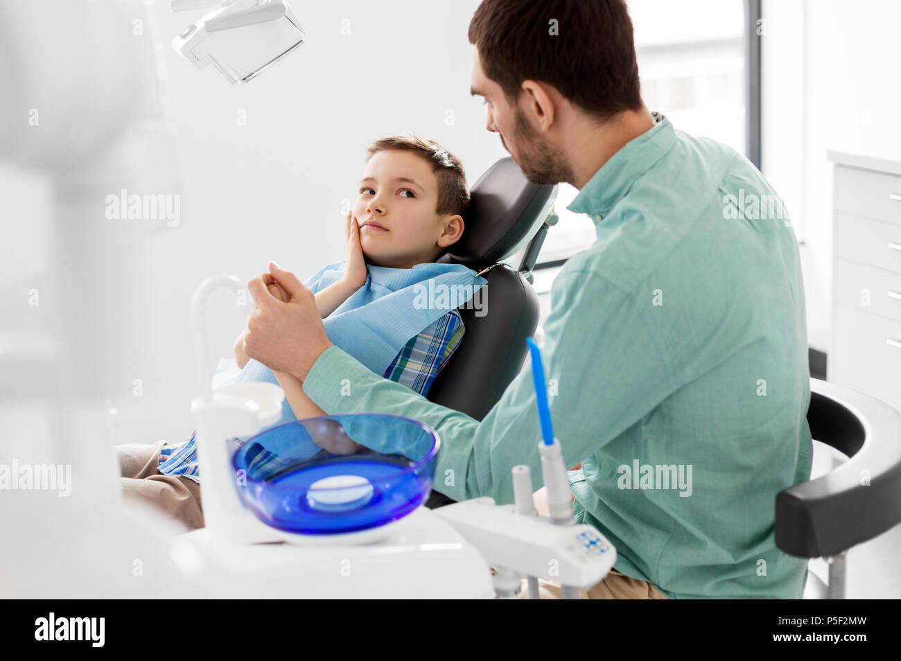father supporting son at dental clinic Stock Photo - Alamy