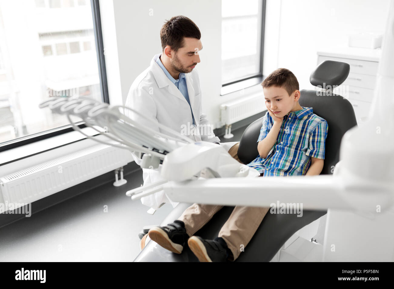dentist with patient having toothache at clinic Stock Photo - Alamy