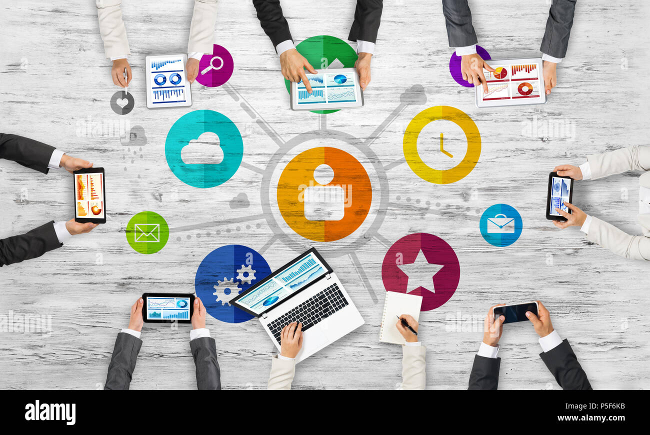 Group of people with devices in hands working together as symbol of ...