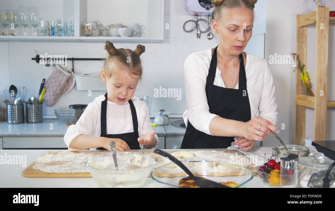 Cute mom and daughter cooking pancakes Stock Photo - Alamy